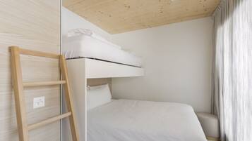 Uma cama beliche com escada de madeira, colchão branco e parede em tom claro.
