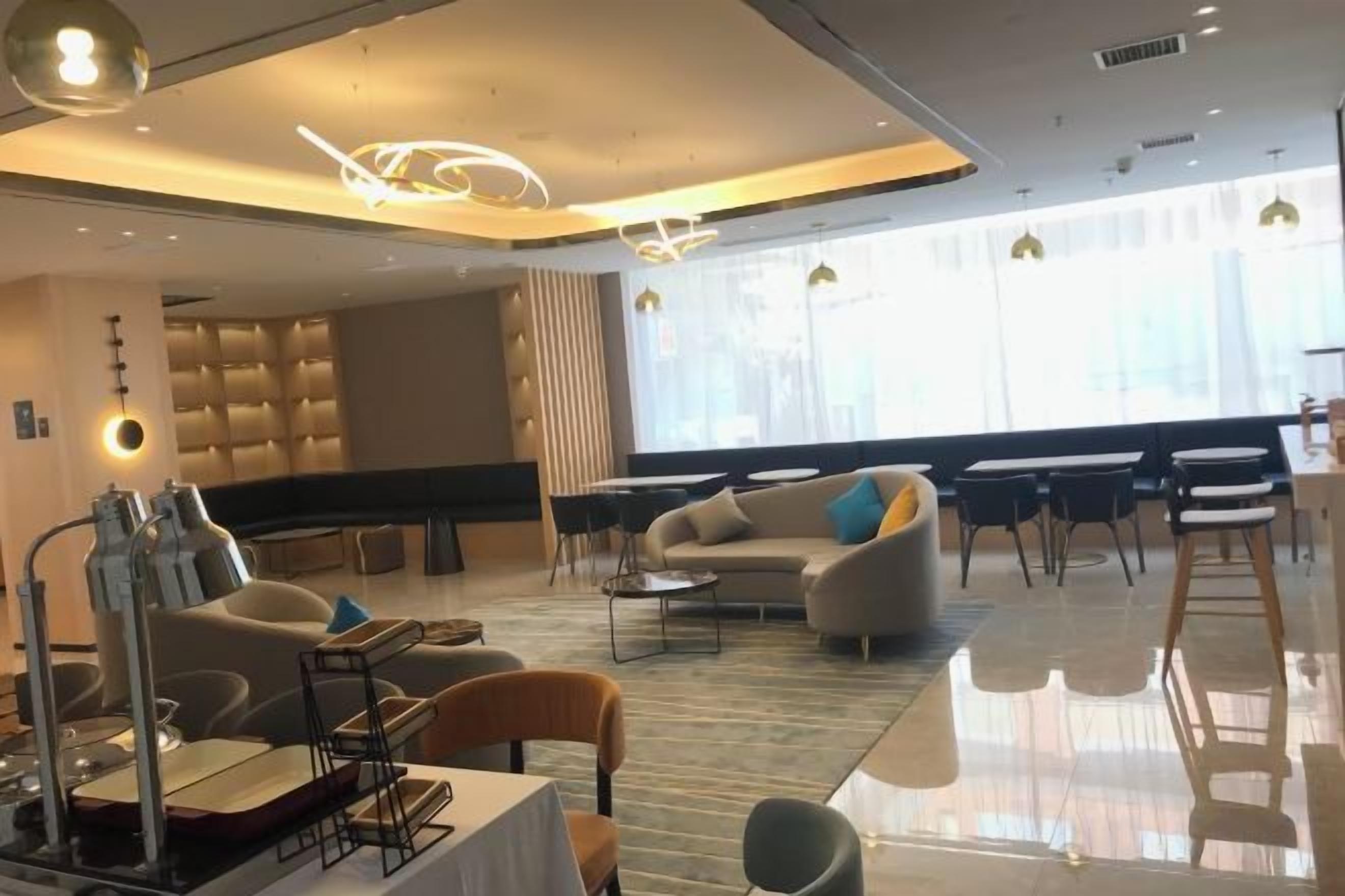 Uma sala de estar moderna com um piano, sofás e um espaço de jantar.