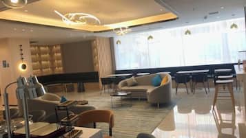 Uma sala de estar moderna com um piano, sofás e um espaço de jantar.