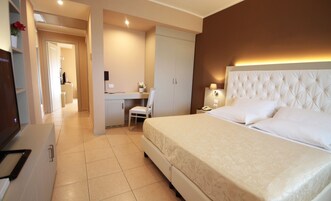 Quarto de hotel com uma cama grande, uma mesa e uma cadeira.