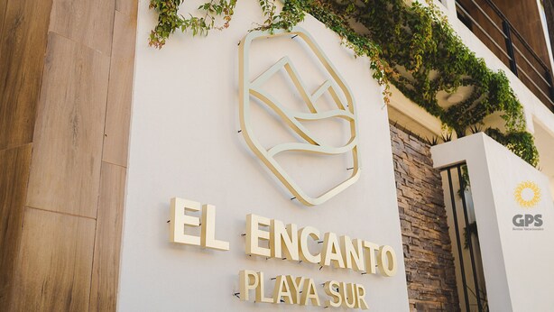 Placa de hotel com o nome 'EL ENCANTO PLAYA SUR' e um logotipo acima.