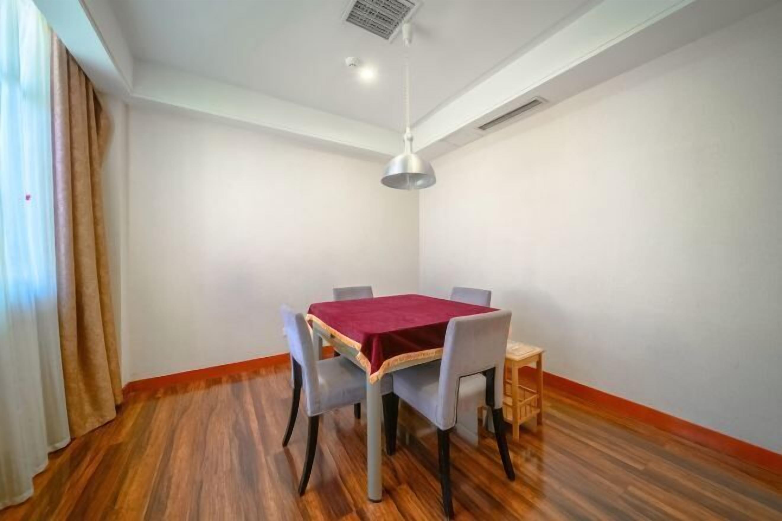 Uma área de refeições com mesa, cadeiras e luminária pendente.