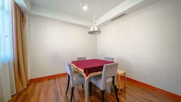 Uma área de refeições com mesa, cadeiras e luminária pendente.