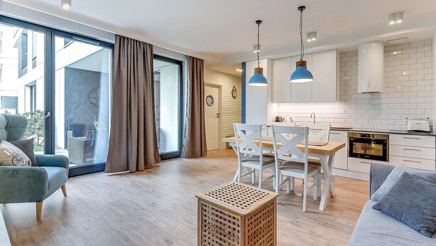 Uma sala de estar moderna com um sofá, uma mesa de centro e um espaço de jantar com cadeiras e uma mesa.