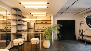 Uma cozinha moderna com eletrodomésticos embutidos, uma grande planta em vaso e um banco de bar.