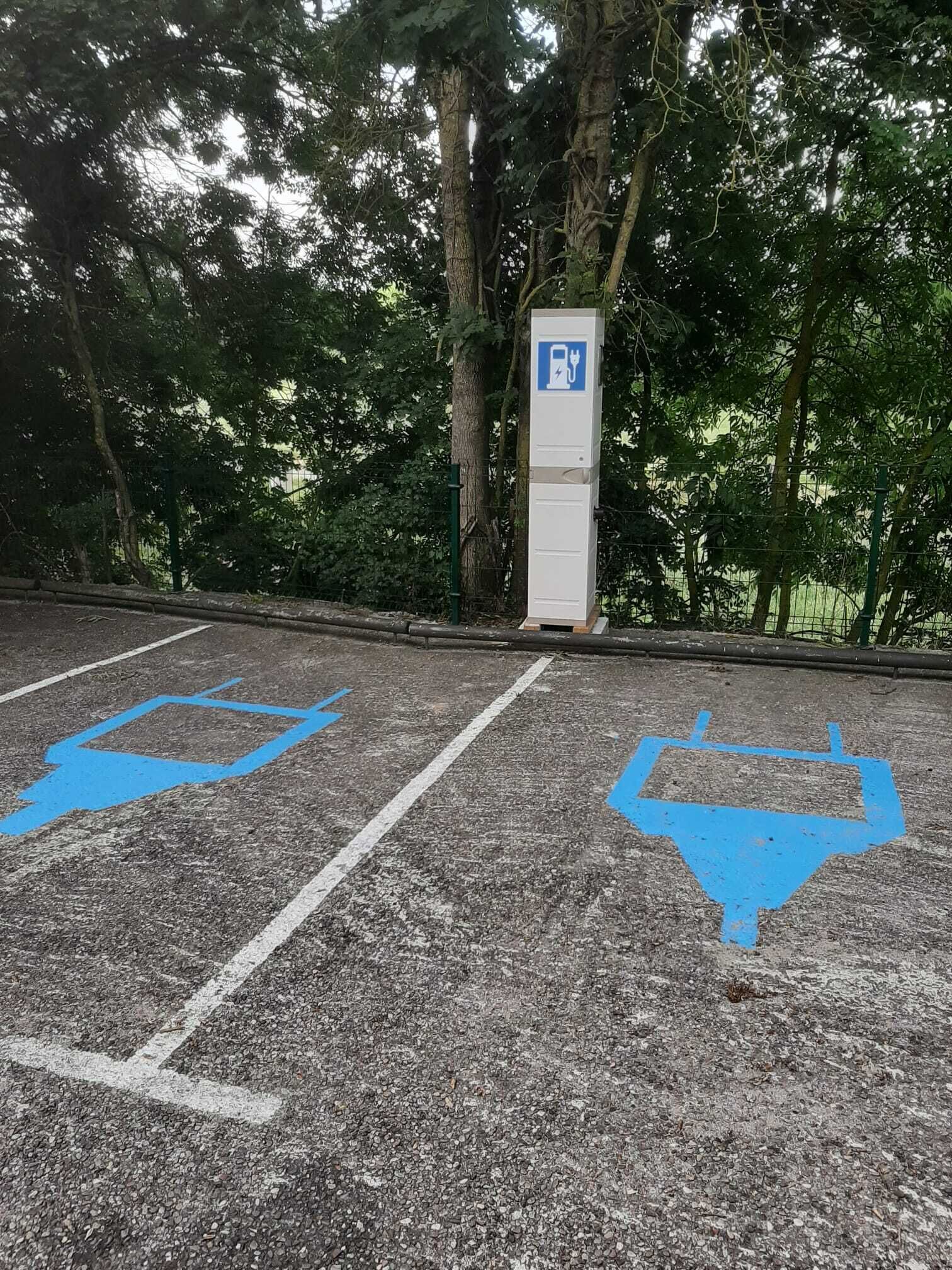Uma área de estacionamento com estações de carregamento para veículos elétricos e vagas designadas.