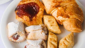 Diversos pastéis e sobremesas em pratos, incluindo uma fatia de bolo e scones.
