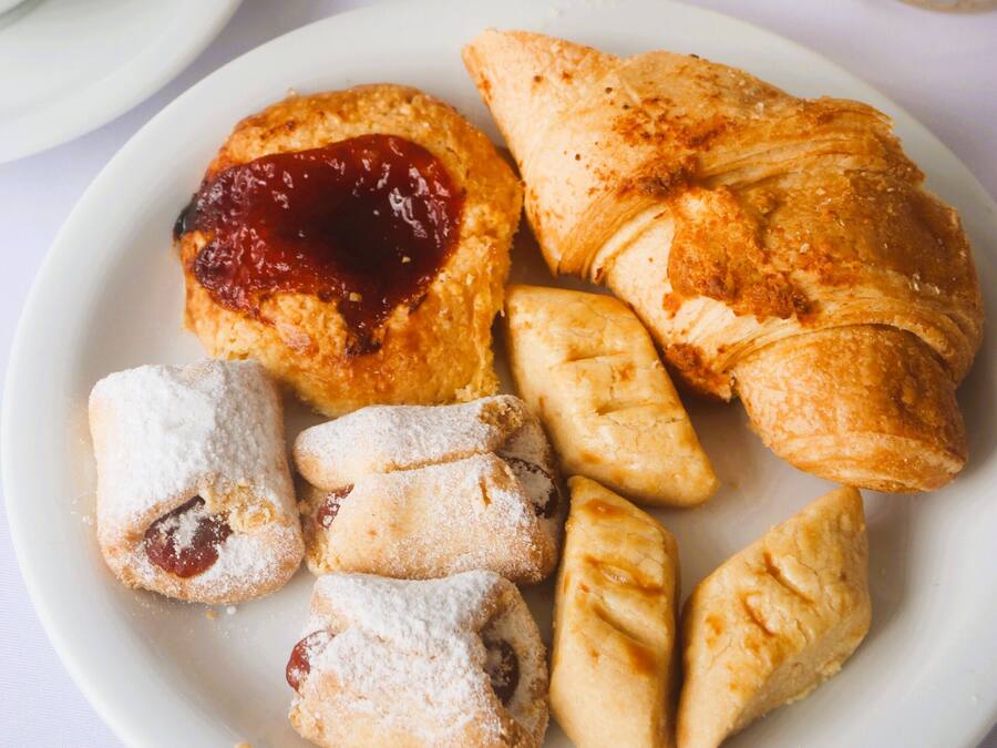 Diversos pastéis e sobremesas em pratos, incluindo uma fatia de bolo e scones.
