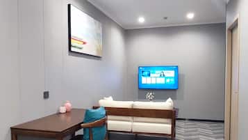 Quarto Familiar, várias camas, Vista para a cidade | Sala de estar | Smart TV de 50 polegadas com canais digitais, televisor