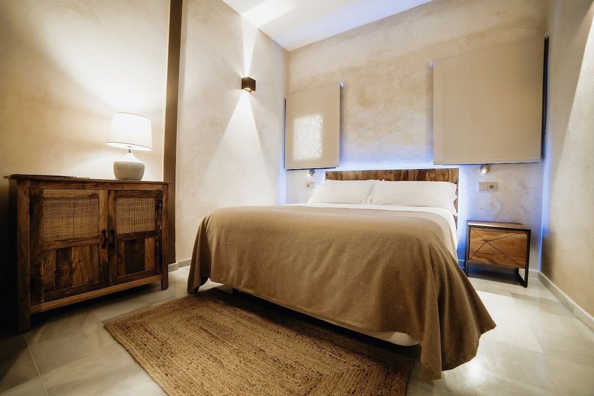 Um quarto com uma cama, um armário de madeira e uma mesa de cabeceira.