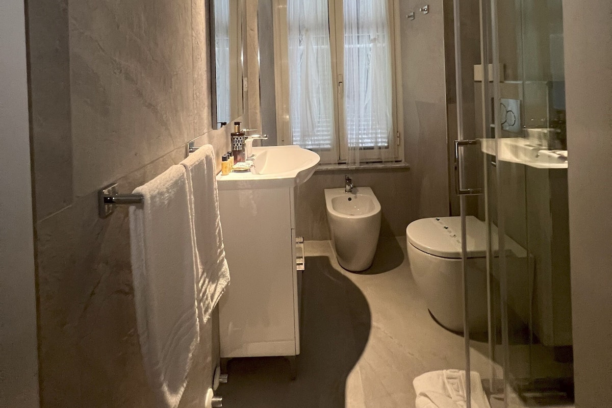 Casa de banho compacta com chuveiro, sanita e lavatório.