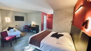 Quarto de hotel com uma cama grande, uma escrivaninha e uma cadeira.
