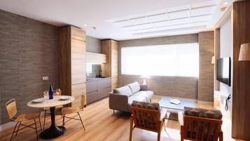 Uma sala de estar moderna com sofá, cadeiras, mesa de jantar e televisão.