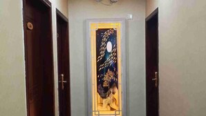Corredor com porta adornada por painel decorativo representando uma cena noturna e uma figura.