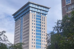 Um edifício alto e moderno, com base retangular e telhado plano.