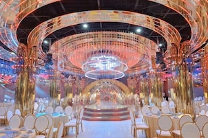 Um espaço para eventos interno, com palco circular, mesas e cadeiras dispostas para o público.