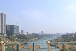 Um rio com uma ponte em primeiro plano e um horizonte urbano ao fundo.