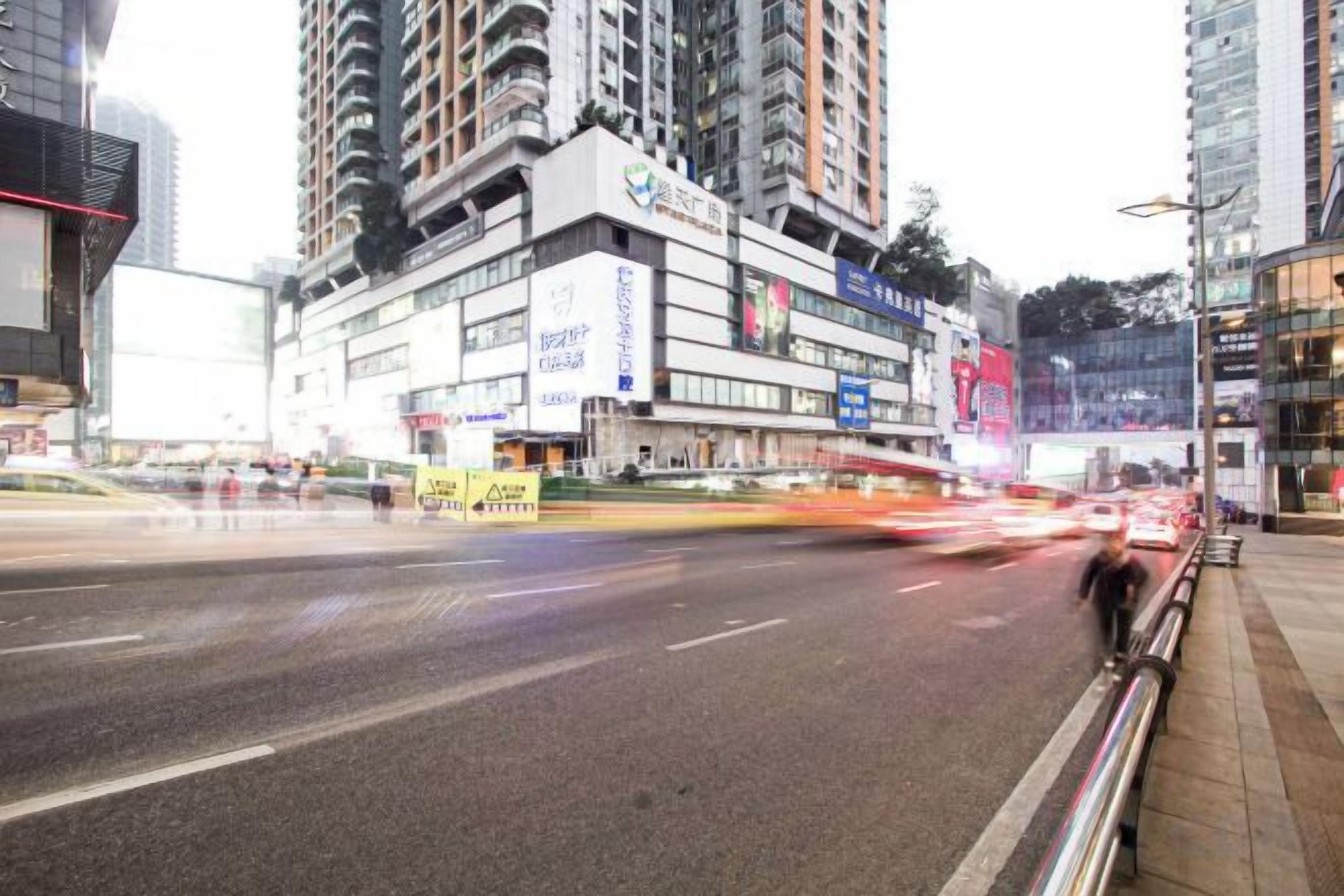Rua urbana movimentada com edifícios altos e sinalização comercial.