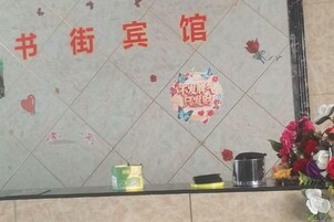 Parede revestida de azulejos com um desenho floral e uma placa.