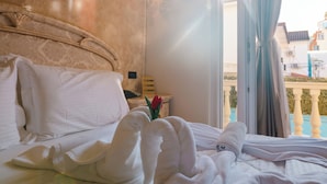 Quarto de hotel com uma cama, mesa de cabeceira, abajur e vista para o exterior.