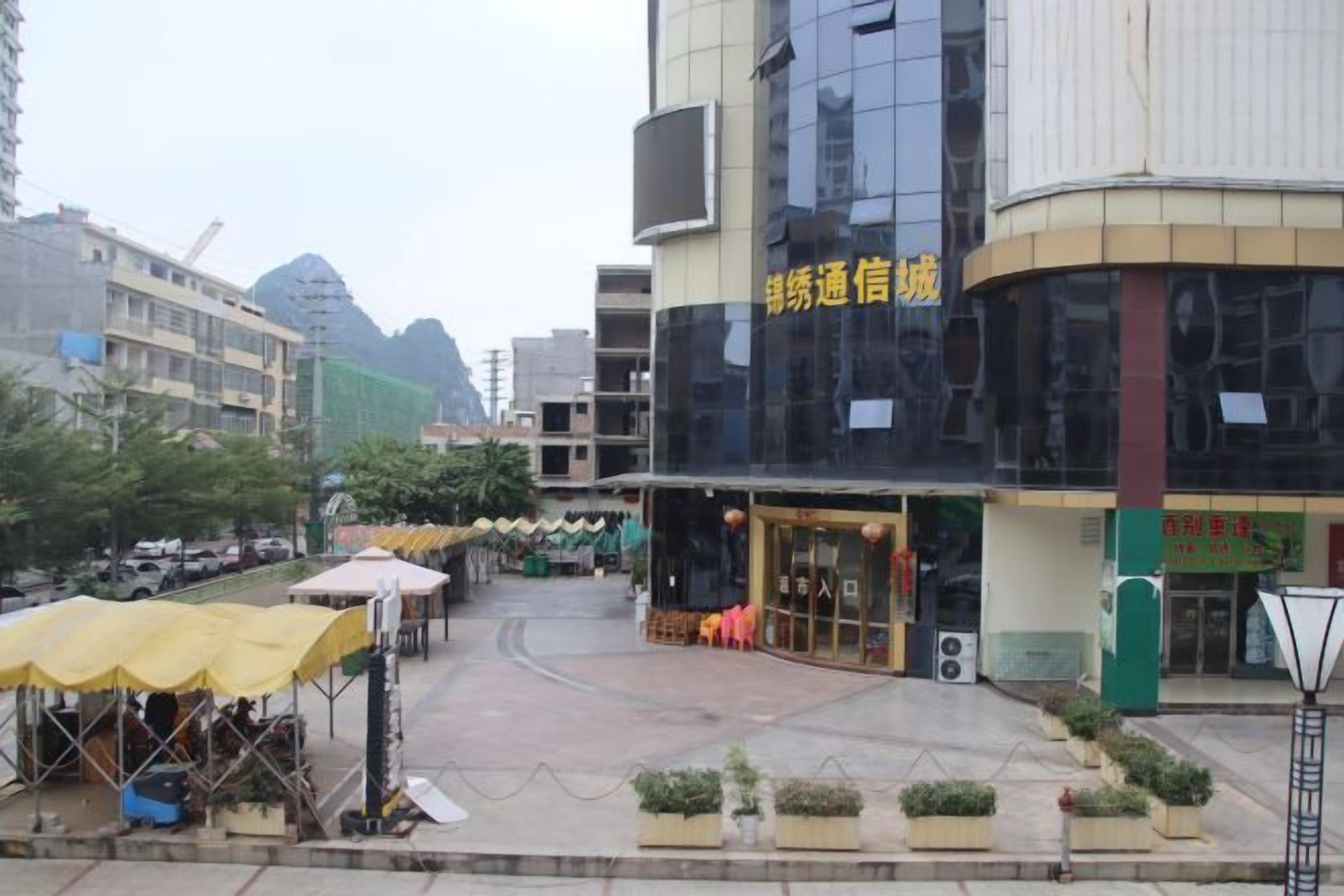 Um edifício comercial com fachada, área de estar ao ar livre e estacionamento.