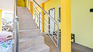 Uma escadaria com guarda-corpos de metal que leva a uma porta com o número 111.
