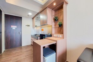 Uma cozinha compacta com armários de madeira, fogão embutido e uma bancada pequena.