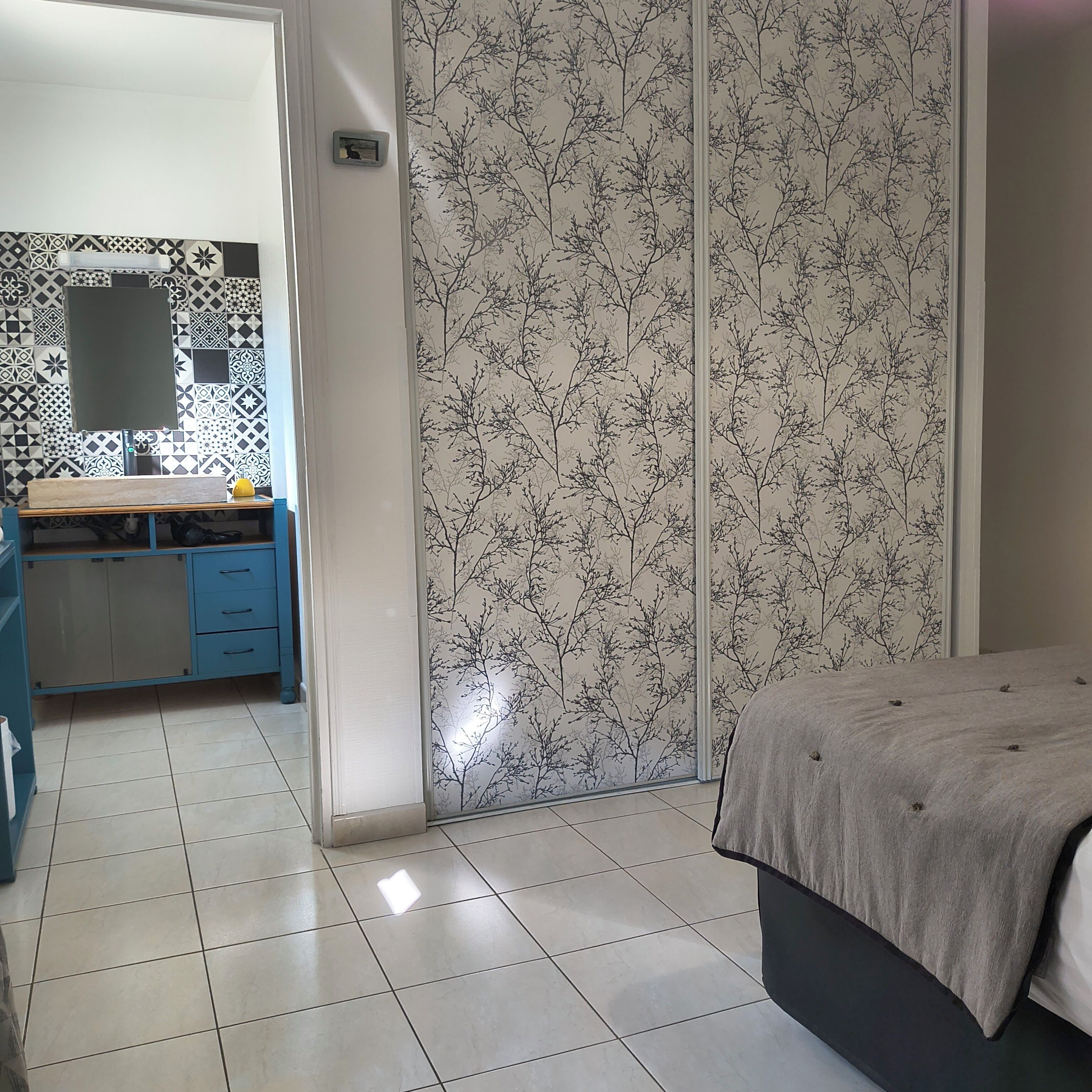 Quarto com cama, guarda-roupa e secretária com cadeira.