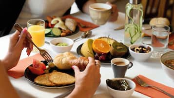 Uma mesa posta para o café da manhã, com diversos alimentos e bebidas.