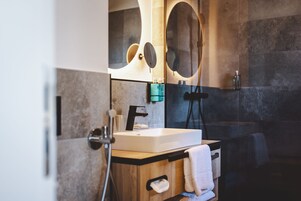 Uma casa de banho moderna com um espelho grande, uma pia e um porta-toalhas.