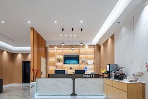 Uma área de recepção moderna com balcão de mármore, televisão de tela plana e iluminação pendente.