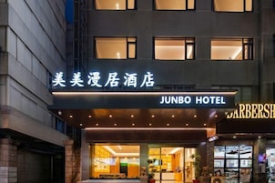 Um hotel com uma fachada onde se lêem 'JUNBO HOTEL' e 'JARBERSH'.