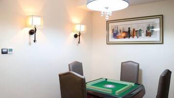 Quarto com mesa de bilhar, duas luminárias de parede e um quadro com vista da cidade emoldurada.