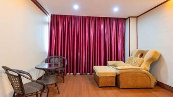 Um quarto com sofá, uma mesinha e duas cadeiras.