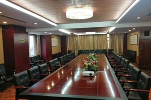 Sala de conferência com uma mesa comprida, cadeiras e um projetor.