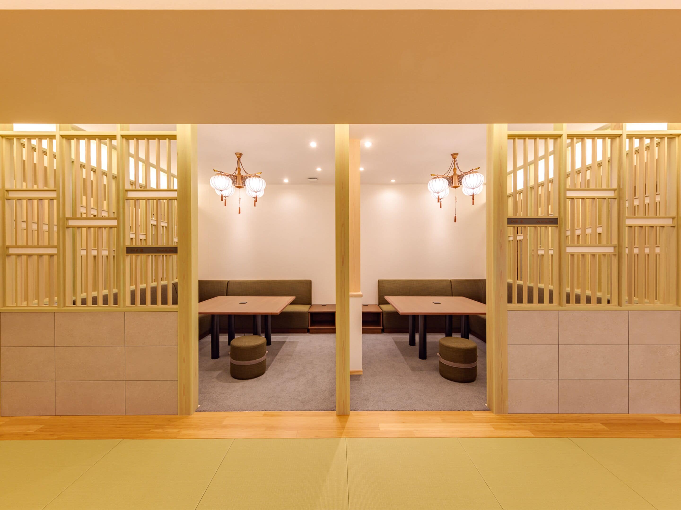 Quarto com parede espelhada, sofá, mesa e luminária suspensa.