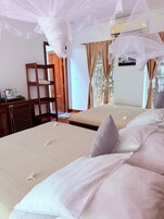 Quarto de hotel com cama, escrivaninha de madeira e janela com cortinas.