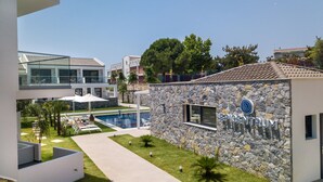 Um edifício moderno com fachada de pedra e área de piscina.