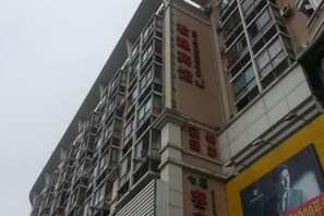 Edifício de vários andares com placas indicando um hotel e um restaurante.