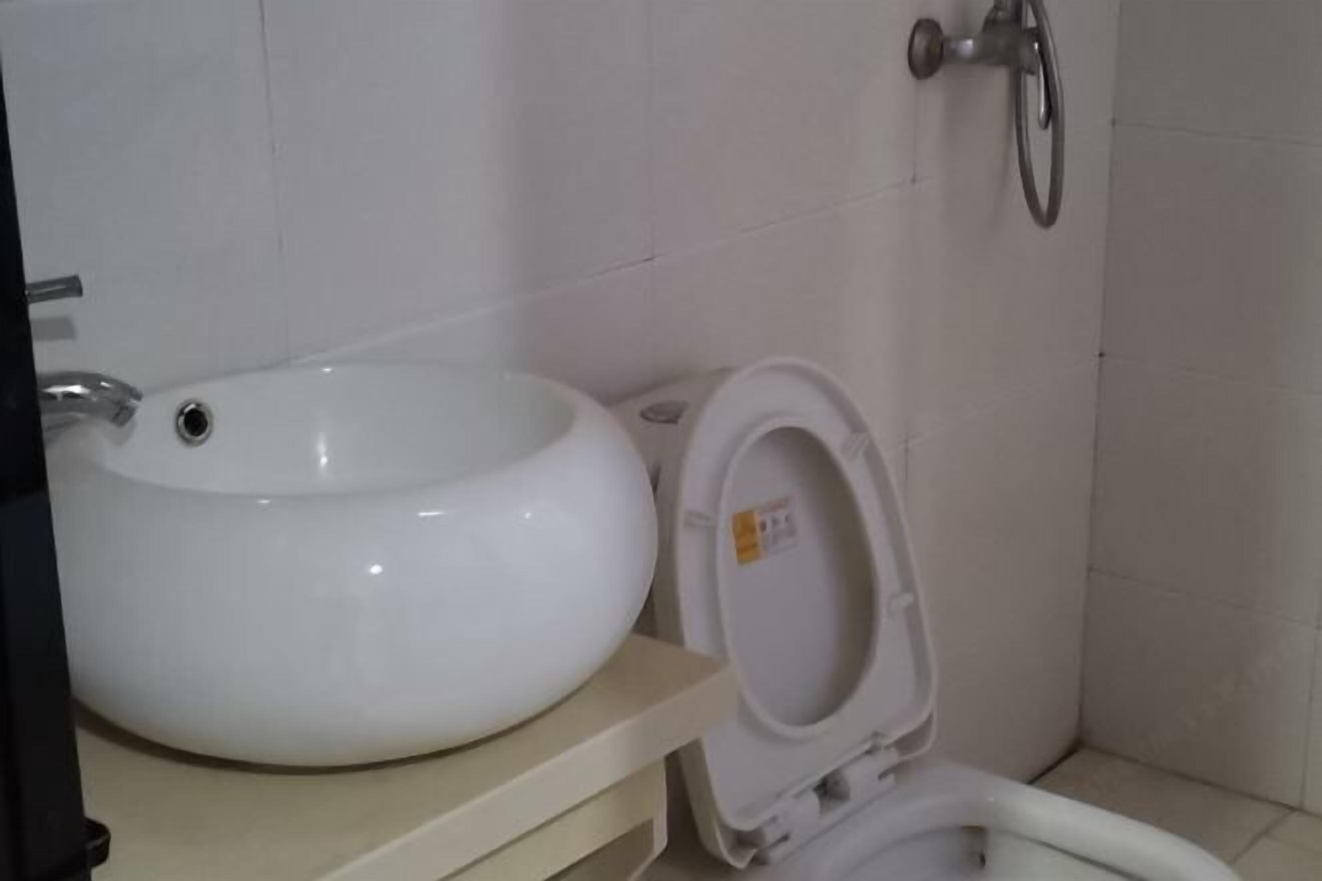 Um banheiro com pia e vaso sanitário brancos.