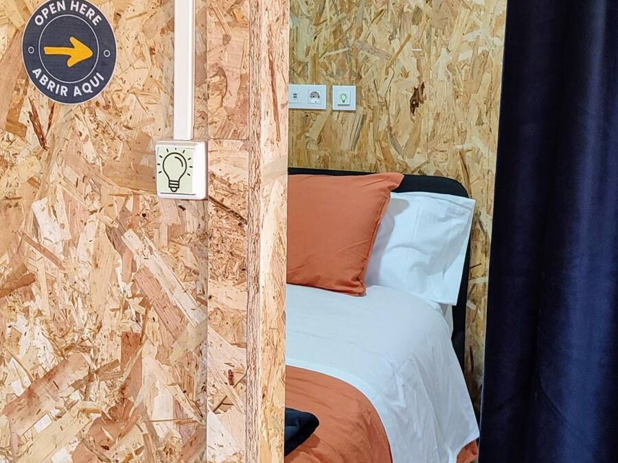 Quarto com uma cama, um interruptor de luz e uma porta com o número 6.