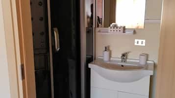 Quarto romântico | Banheiro | Chuveiro com efeito de chuva, secador de cabelo, bidê, toalhas de banho