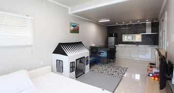 Um apartamento moderno com casa de brincar, cozinha e sala de estar.