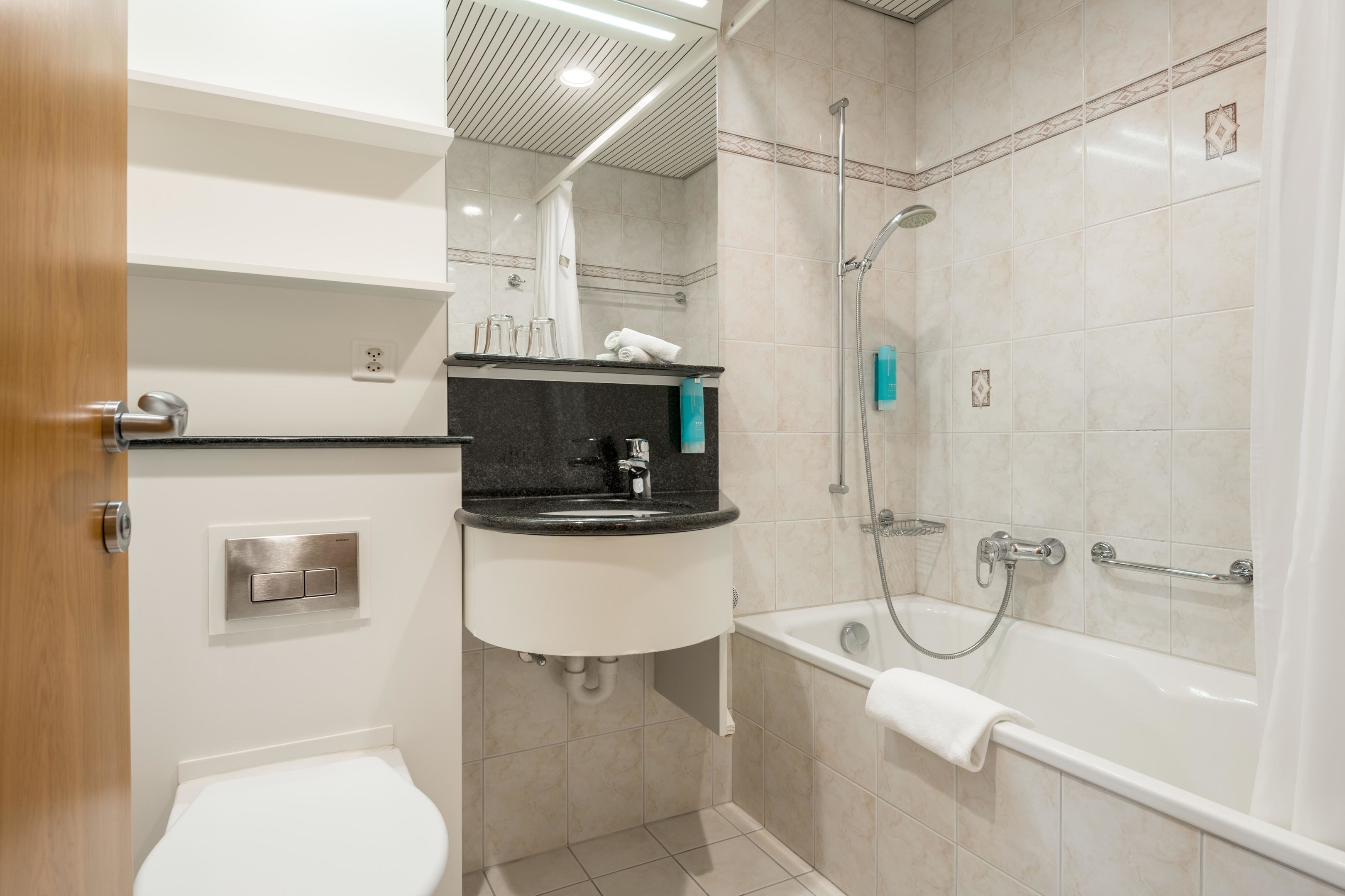 Uma casa de banho moderna com sanita, lavatório e banheira.
