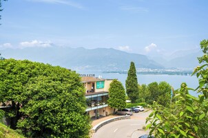 Um hotel com vista para montanhas e um lago.