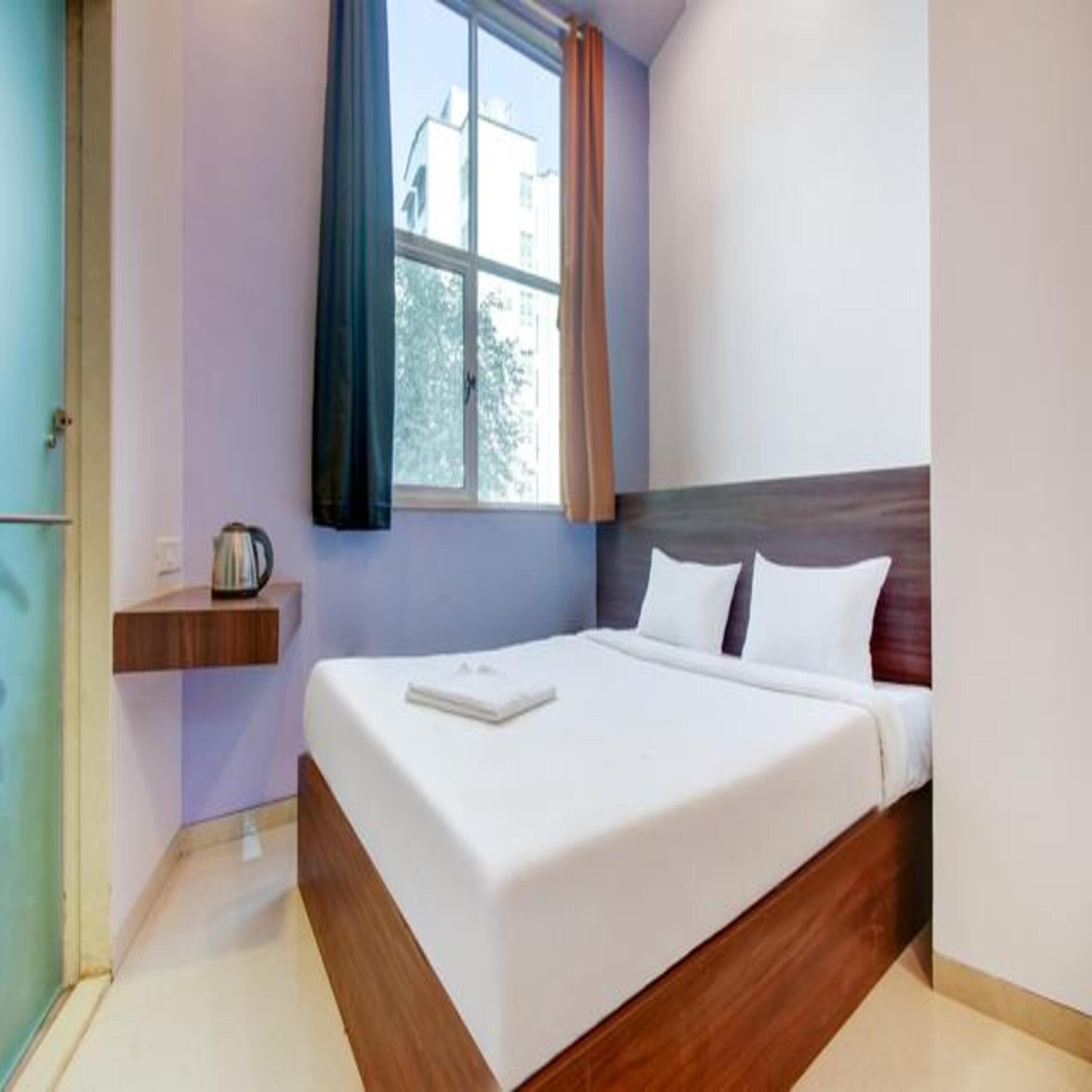 Quarto com cama, janela com cortinas, mesa de cabeceira e peseira de madeira.