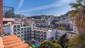 Um edifício alto com várias varandas e área de piscina.