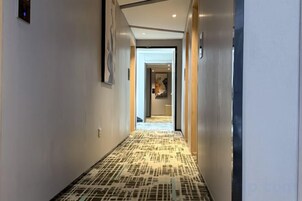 Um corredor com piso estampado e uma porta que dá para um quarto.
