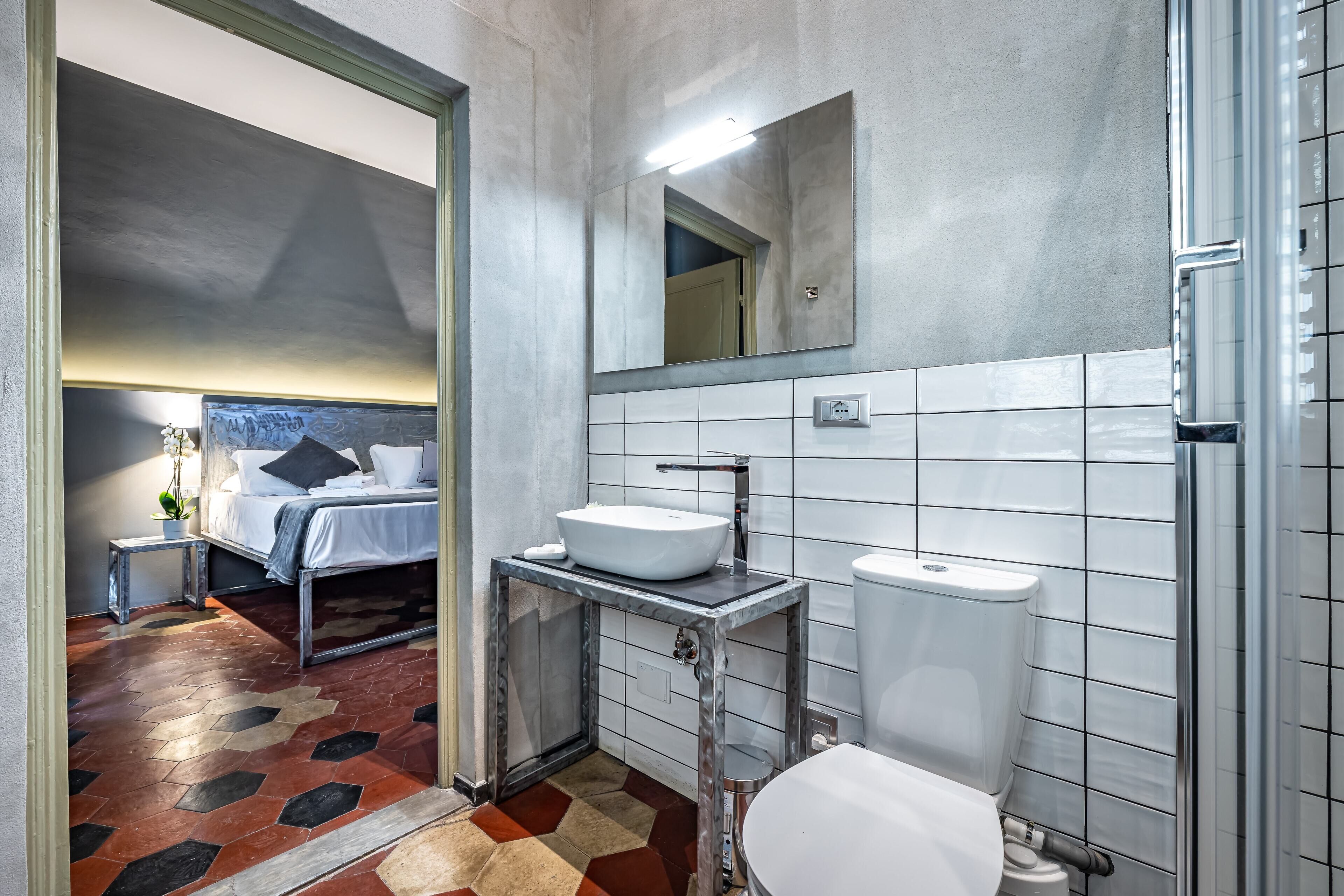 Uma casa de banho moderna com uma sanita, um lavatório branco e um espelho.