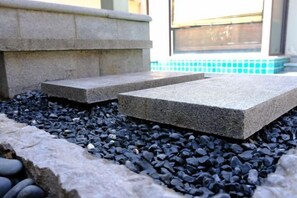 Um banco de pedra com degraus que levam a uma área de cascalho.